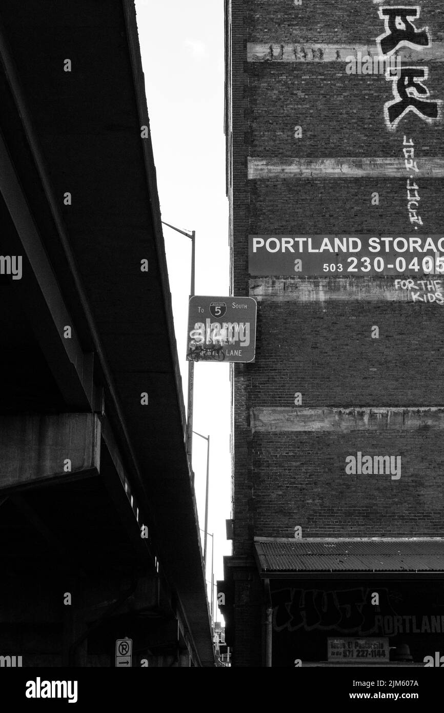 A grayscale low angle shot of a freeway sign that is framed by a ...