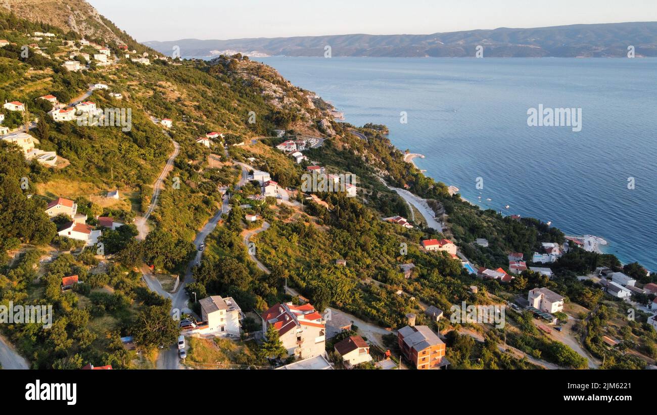 An aerial view of a landscape with roads and houses with a sea on the ...