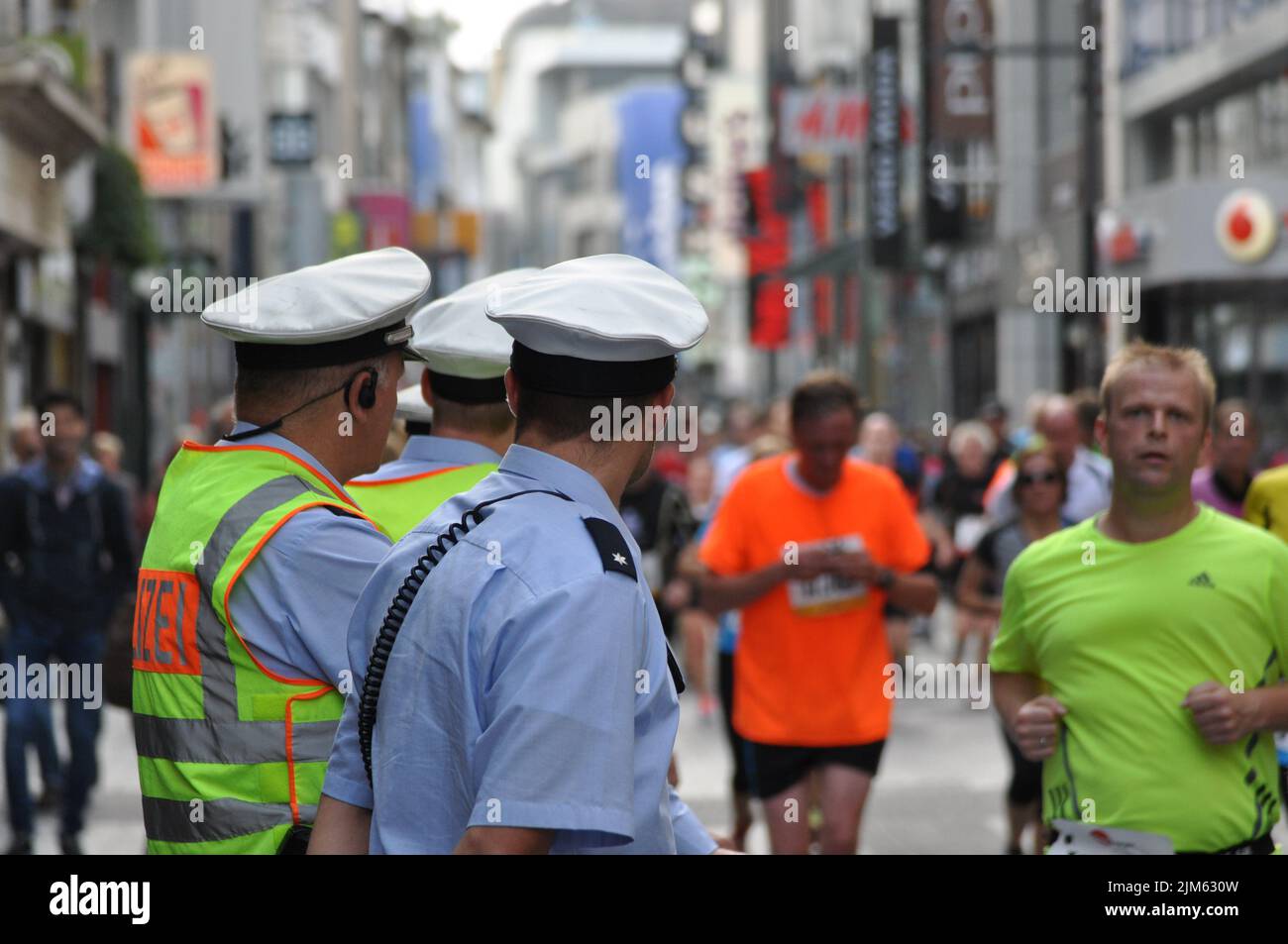 A shallow focus shot of three policemen watching running marathon ...
