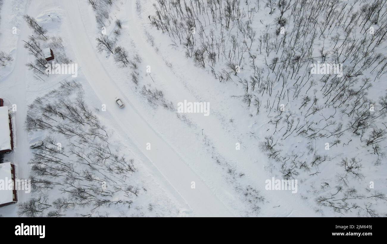 An aerial view of a vehicle on a road cutting through fields covered ...