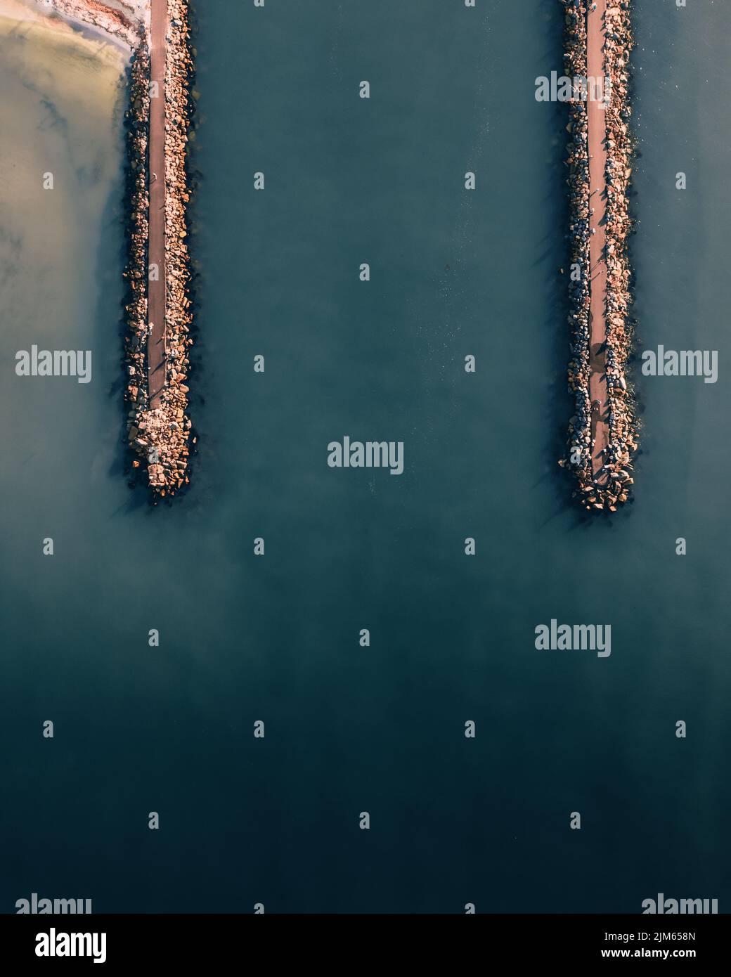 A vertical aerial top view of rocky pathways in the ocean Stock Photo ...