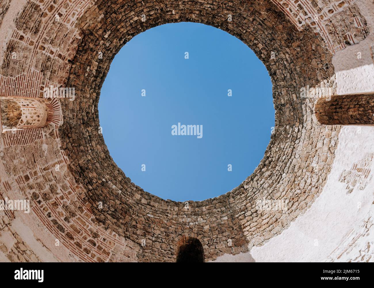 A low angle shot of oculus on an old roman building on a sunny day with ...