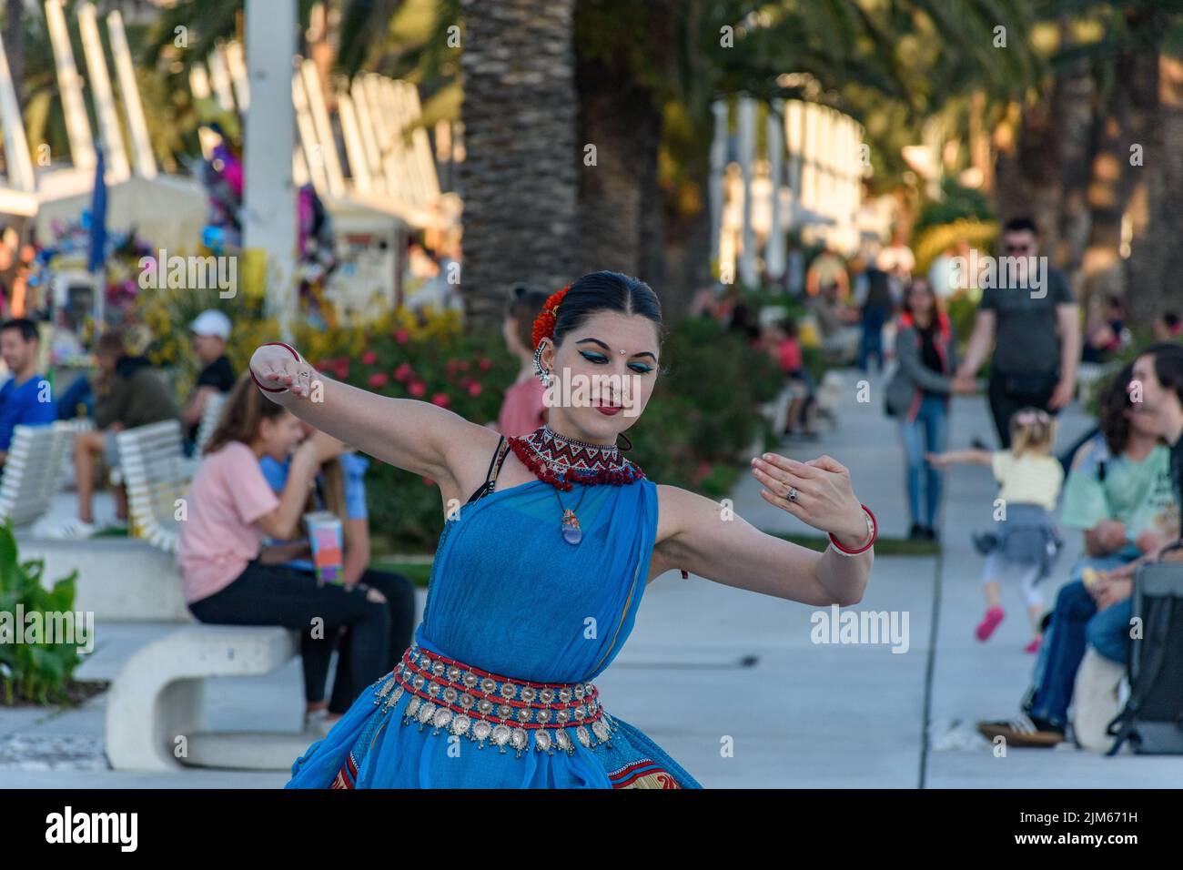 A female street artist performs traditional Asian dance with hand ...