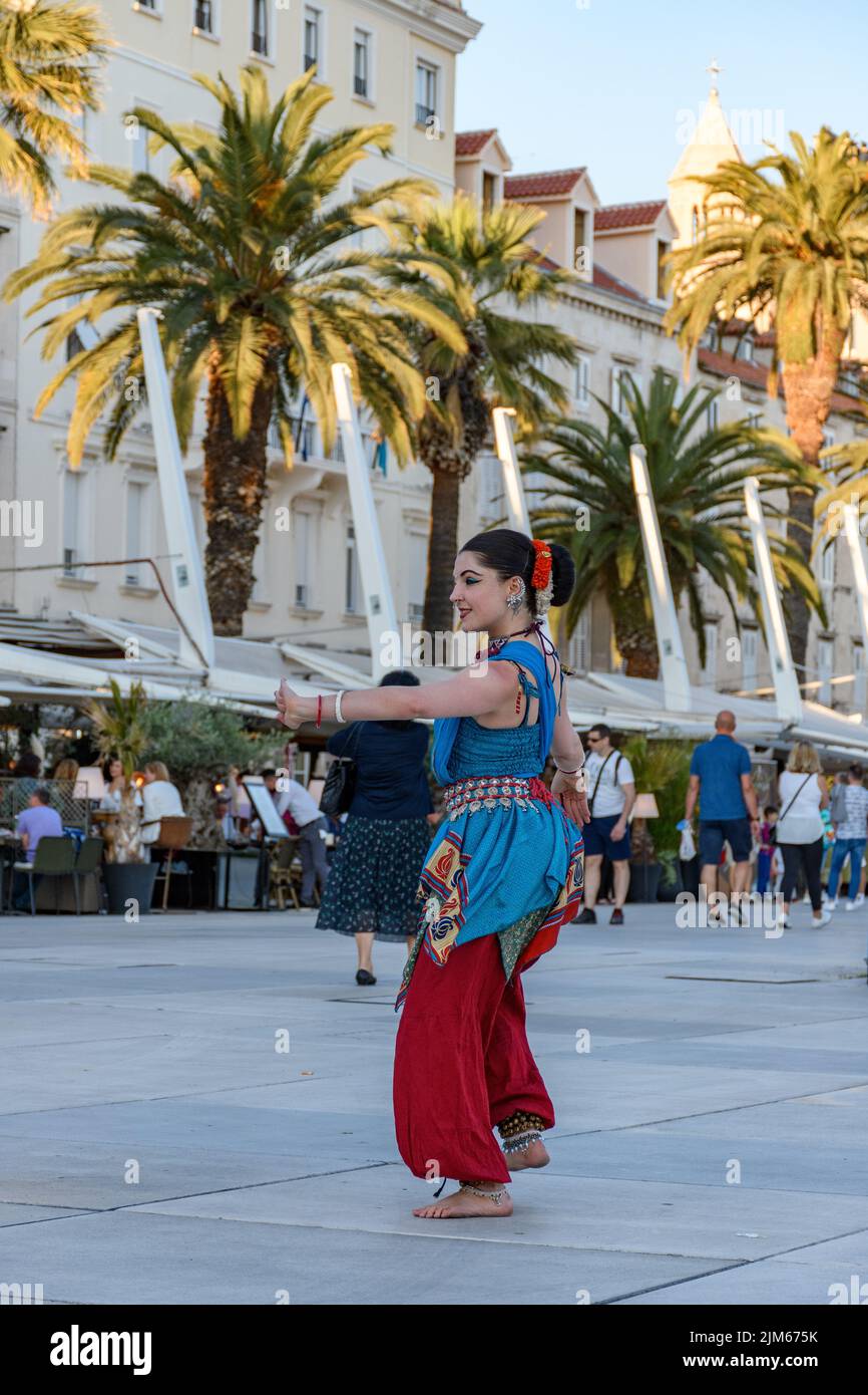 A female street artist performs traditional Asian dance with hand ...