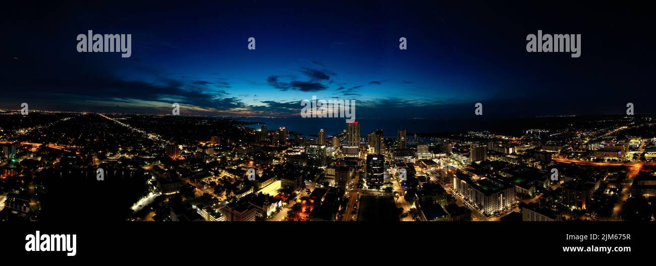 A panoramic scene of night cityscape with buildings lights and cloudy ...