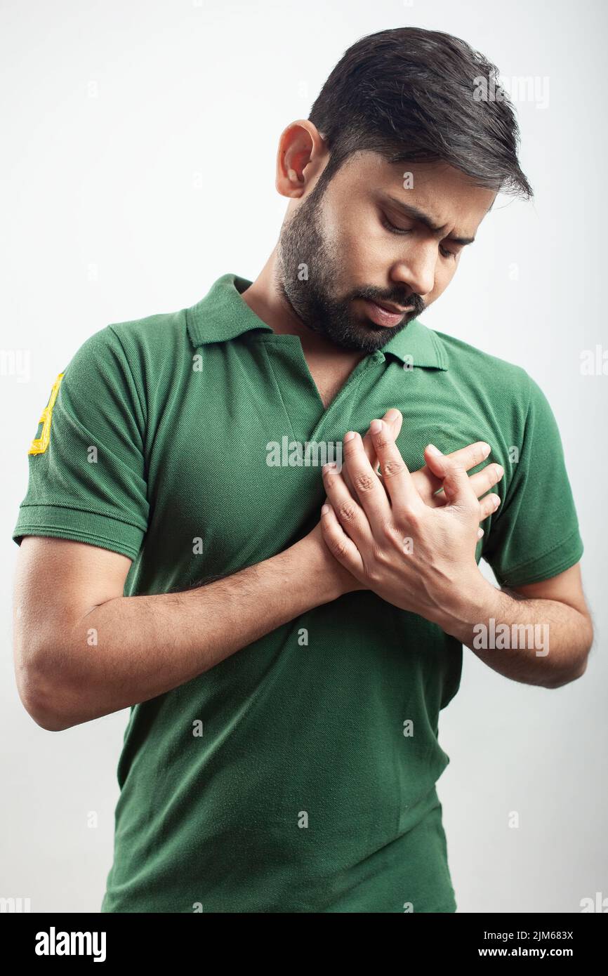 Caucasian young male suffering from chest pain with worried face ...