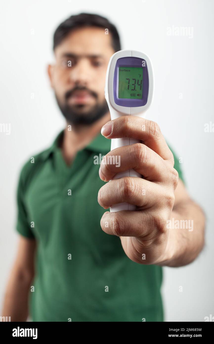 Indian guy showing his body temperature in a contactless digital ...
