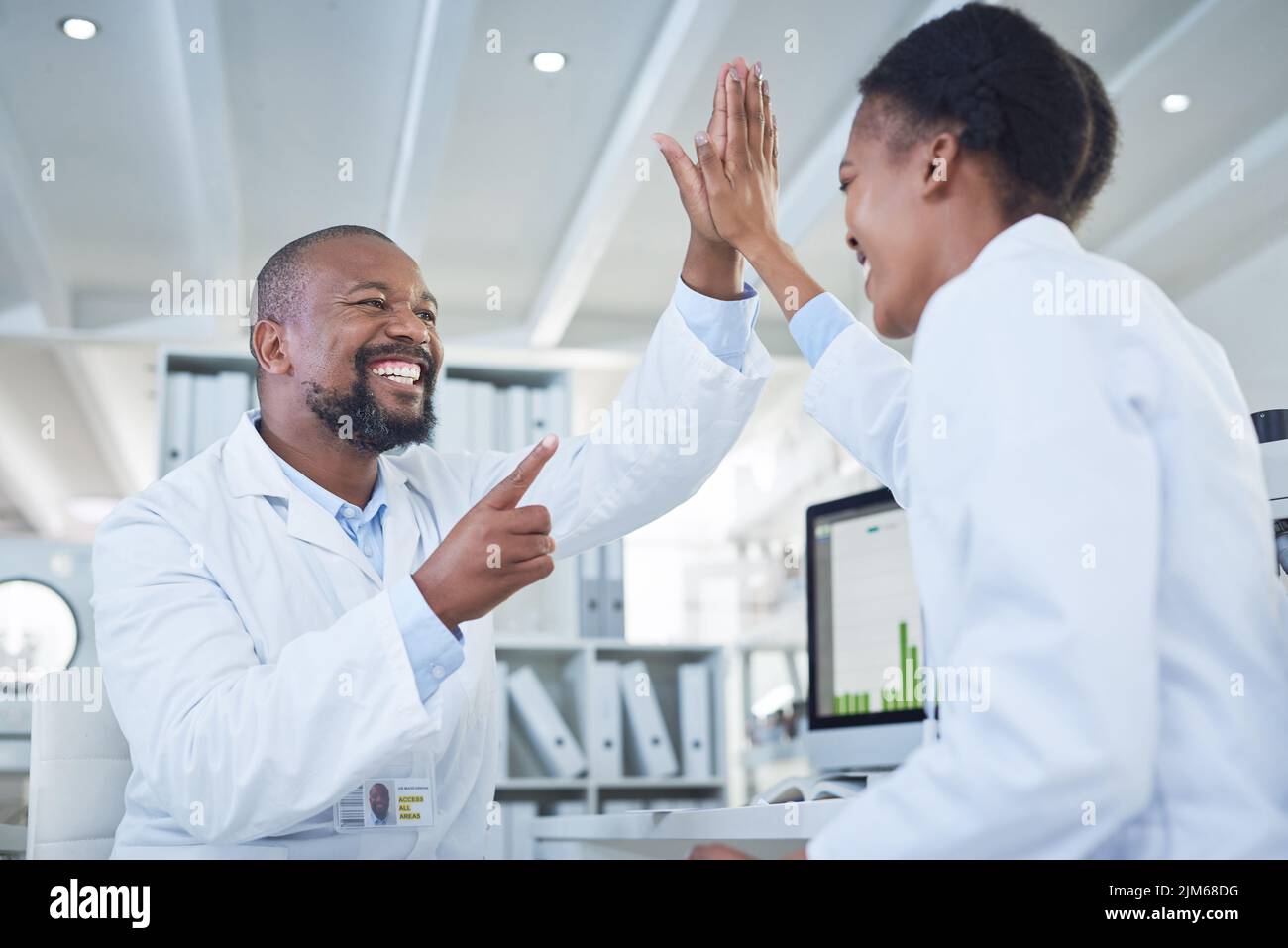 Science saves the day. two scientists giving each other a high five ...
