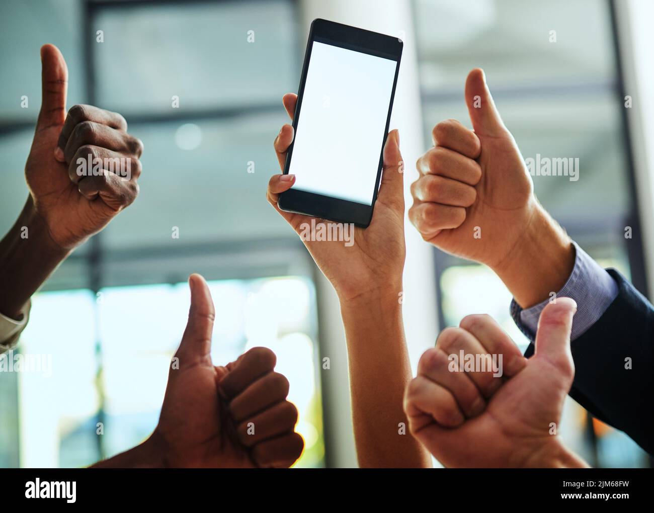 Thumbs up, support and blank phone screen shown by professional ...