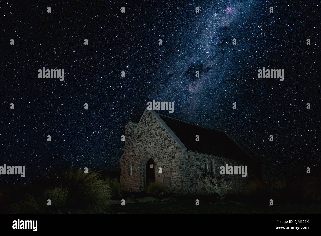 A view of a single-storey stone building in a rural area at night with ...