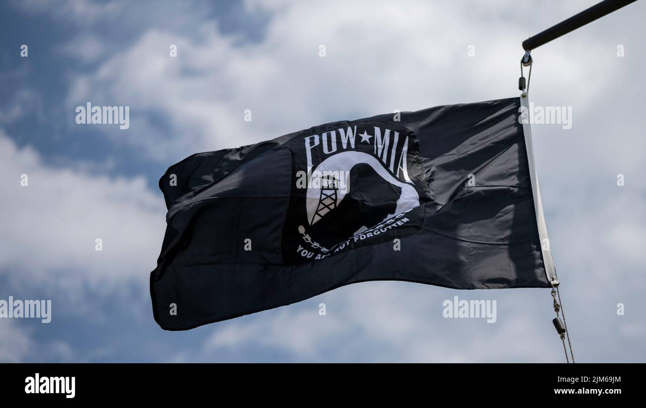 A low angle shot of the POW MIA flag waving on a pole Stock Photo - Alamy