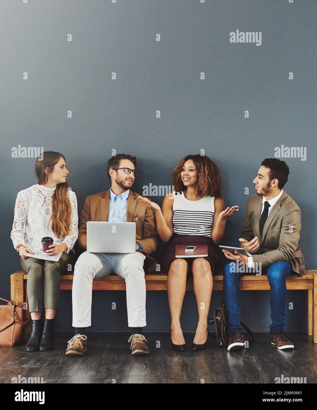 Happy business people working with technology, talking while sitting in ...