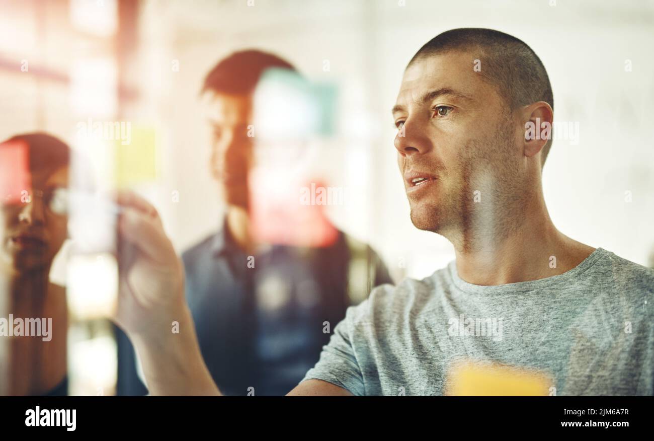 Businessman planning ideas on a transparent board thinking ...