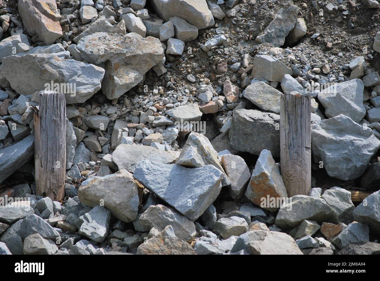 A close-up shot of a pile of rocks and two, small wooden logs Stock ...