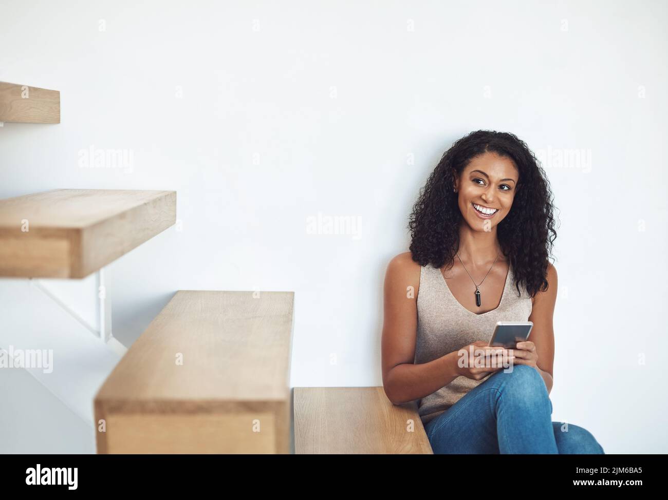 Relaxed woman texting on phone while thinking, planning and dreaming of ...