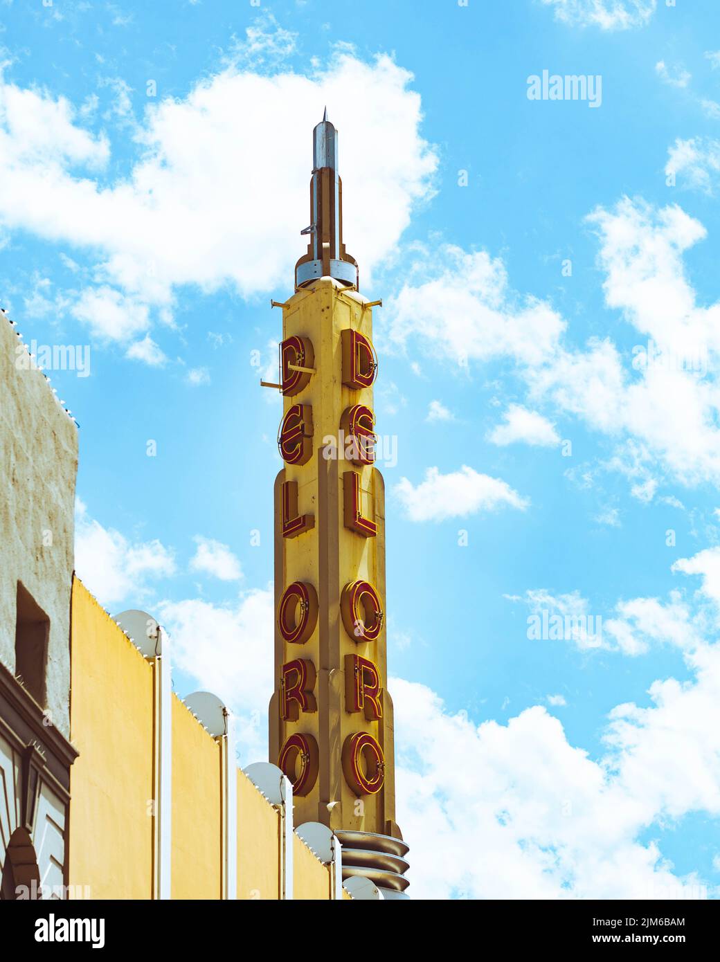 The famous Del Oro movie theater tower against a bright blue cloudy sky ...