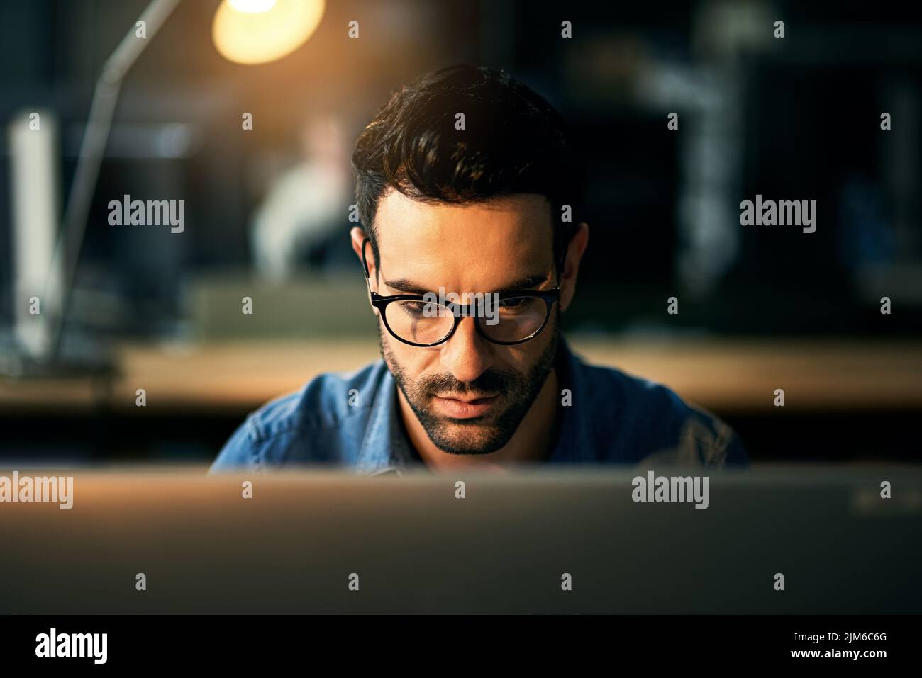 IT guy working with computer late at night, searching online while ...