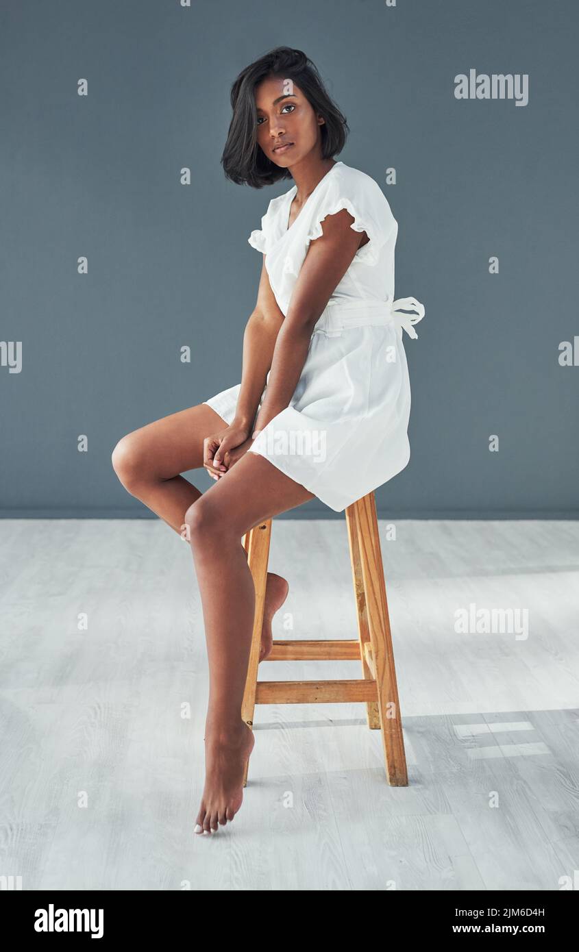 Its summer, show some leg. a beautiful young woman sitting on a chair ...