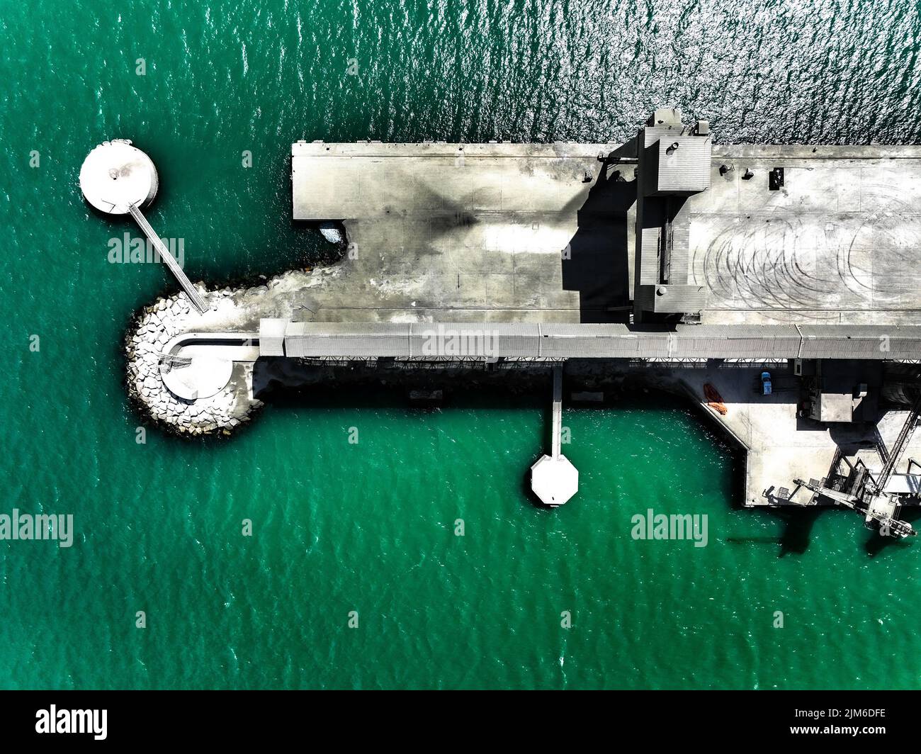 An areal view of a stone pier surrounded by water with beautiful color ...