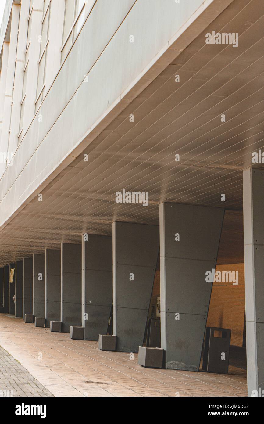 An empty building entrance with columns and a trash can Stock Photo - Alamy