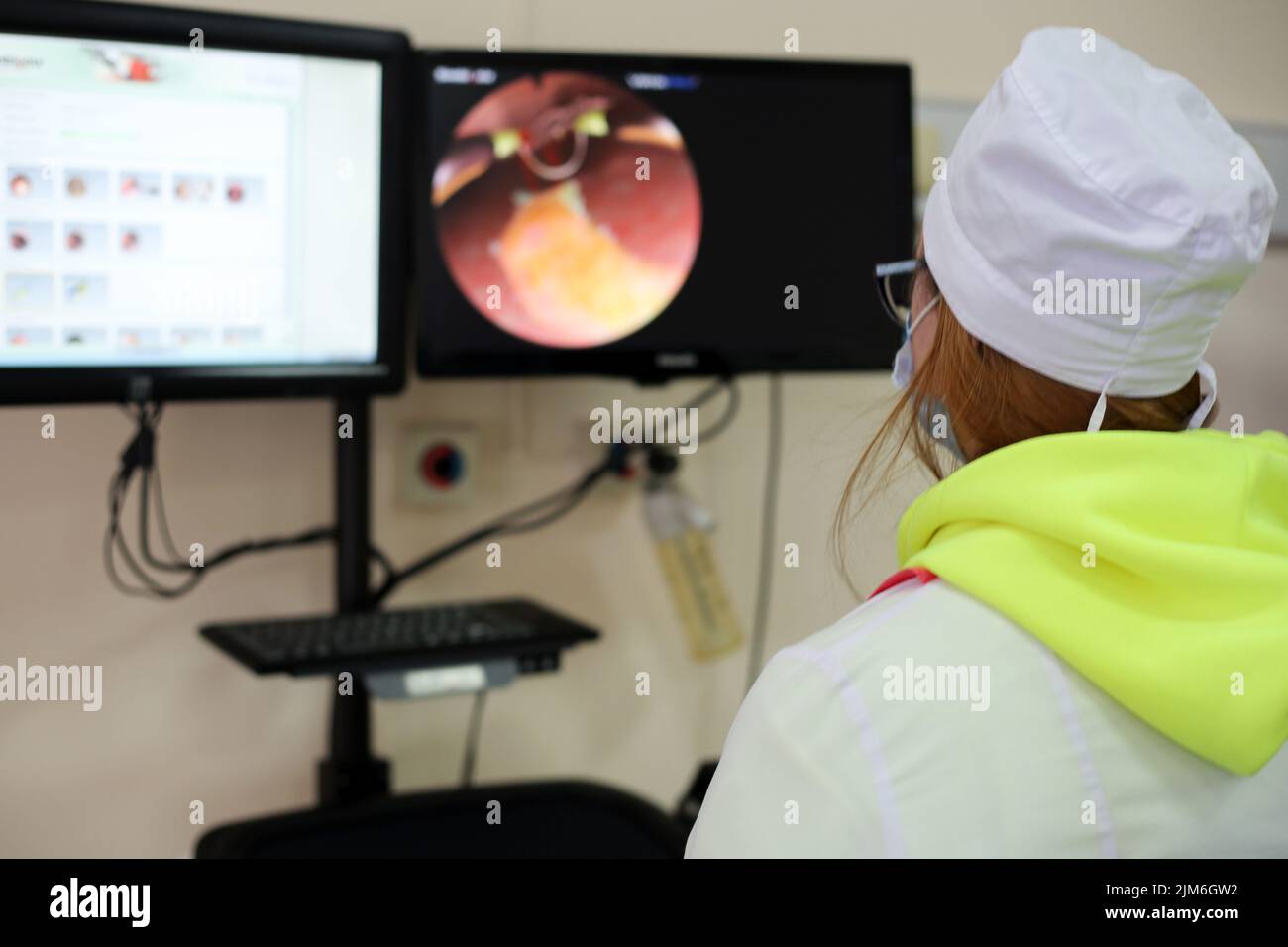 A medical student wearing a protective face mask is seen studying ...
