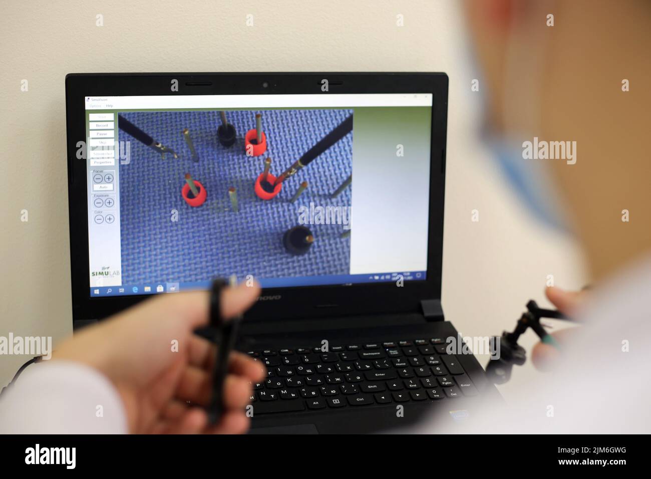 A medical student wearing a protective face mask is seen studying ...