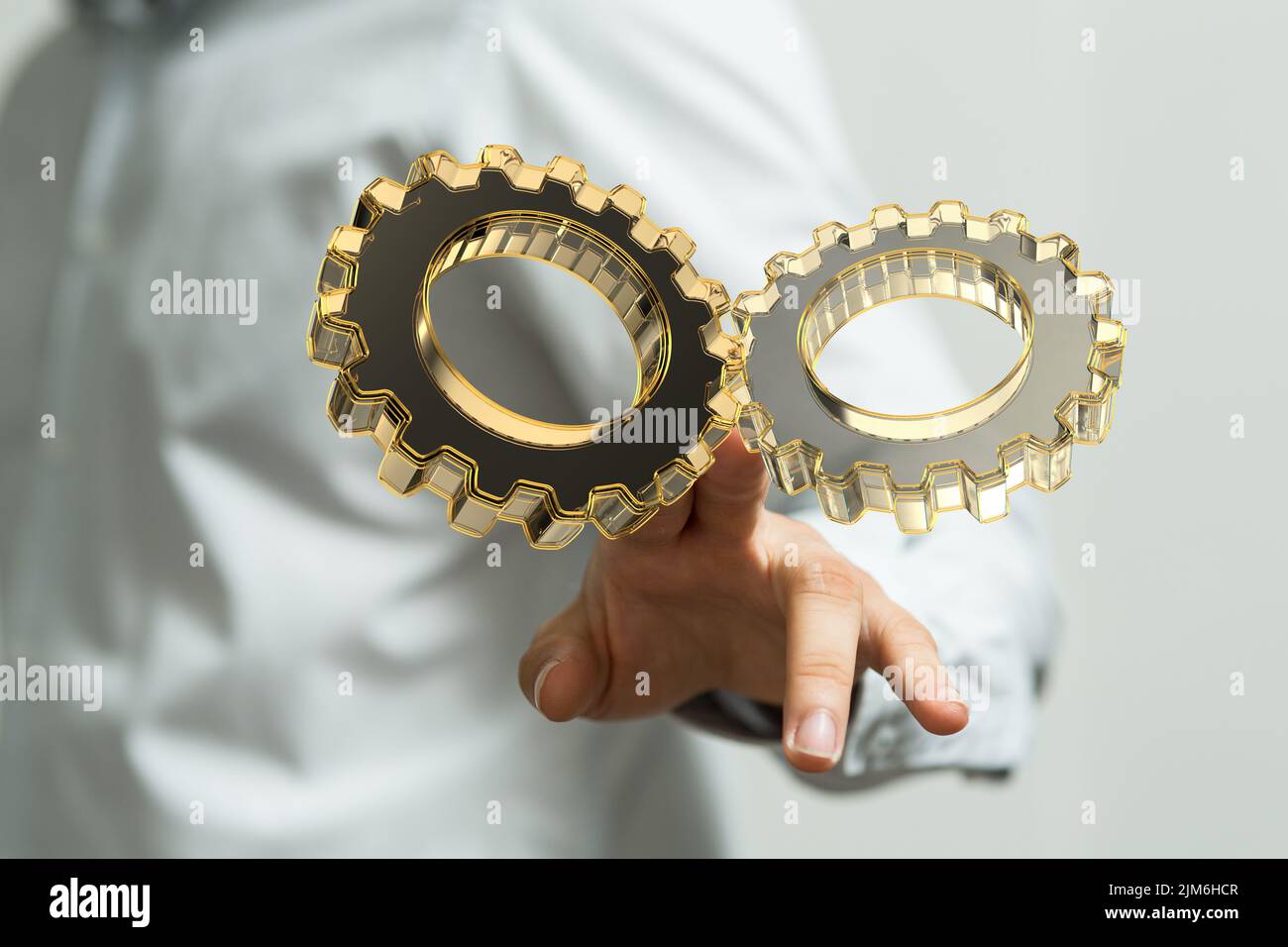 A person tapping on a floating render of turning golden gears Stock ...