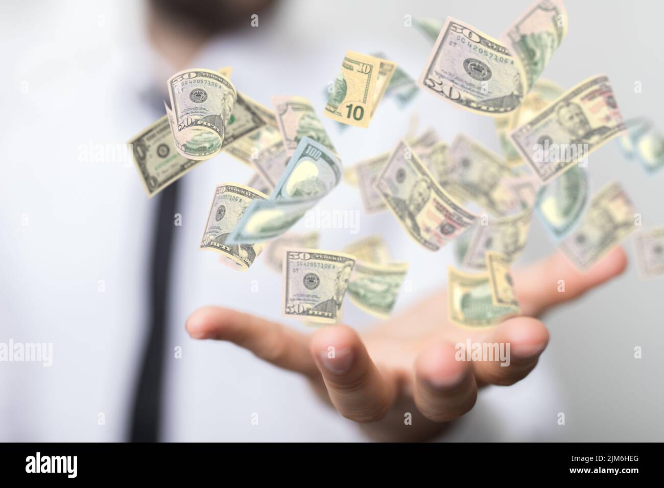 A businessman holding a floating render of different dollar bills Stock ...