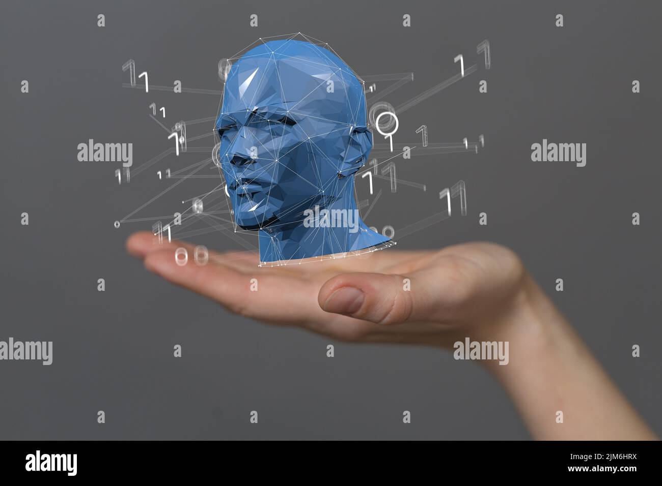 A businessman's hand holding a digital render of a human head hologram ...