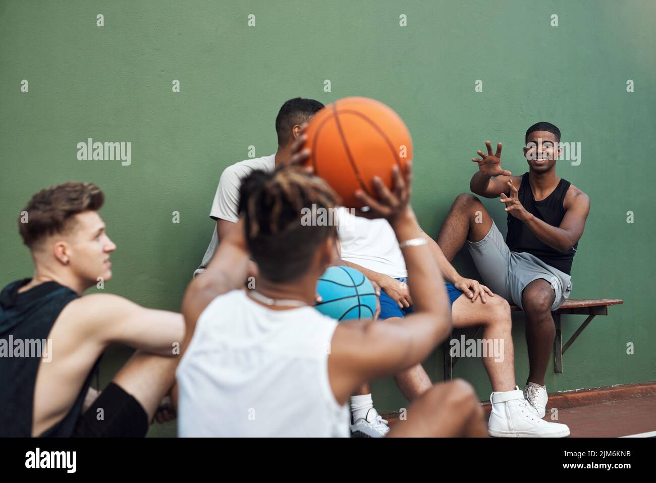 Here, catch. a group of sporty young men hanging out on a basketball ...