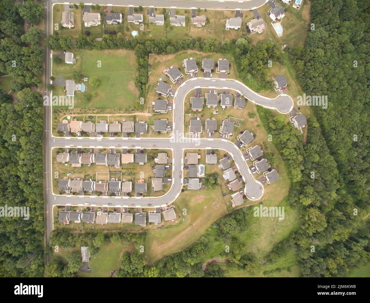 A top view of houses and crossed paths surrounded by green nature Stock ...