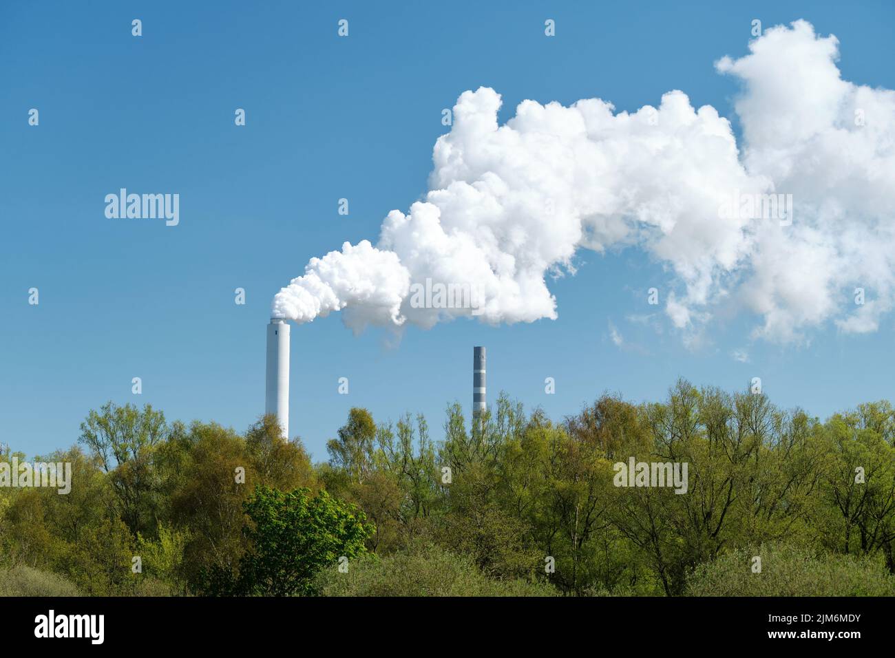 An active coal-fired power plant with a steaming cooling tower in front ...