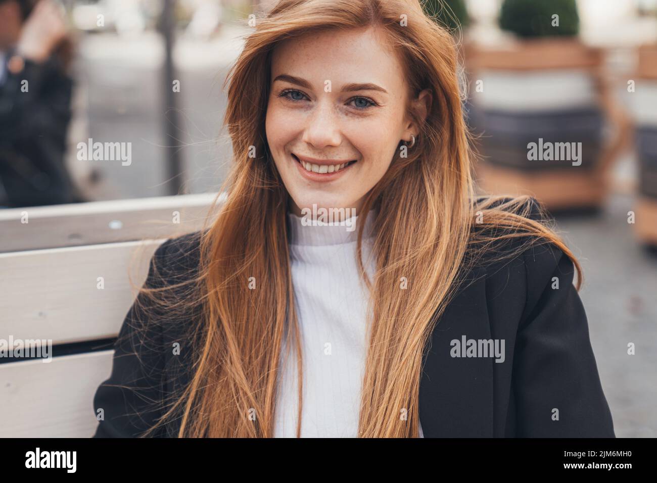 Businesswoman portrait with long foxy hair and freckled face looking at ...
