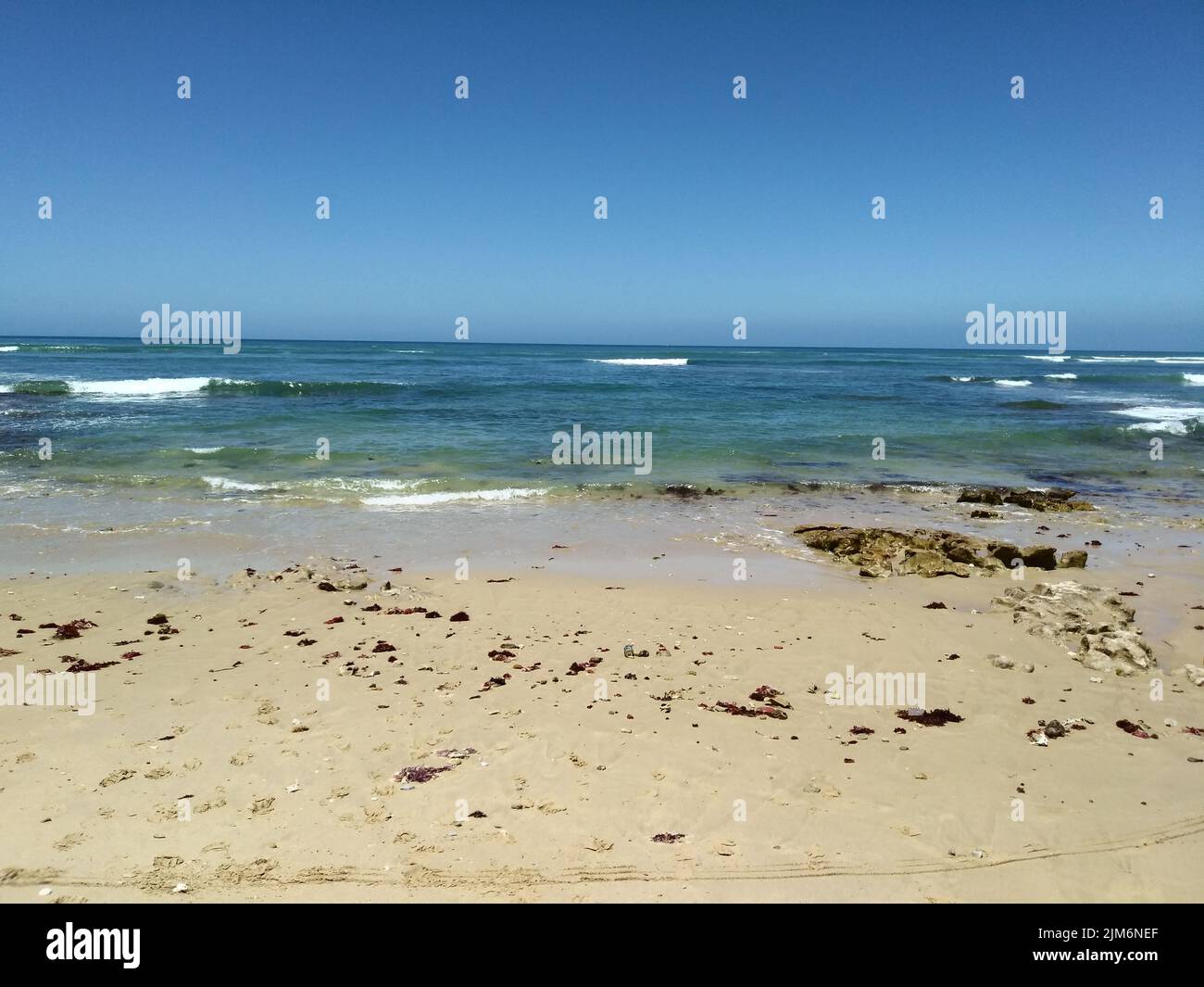 The scenery of a sandy beach on the background of ocean waves captured ...