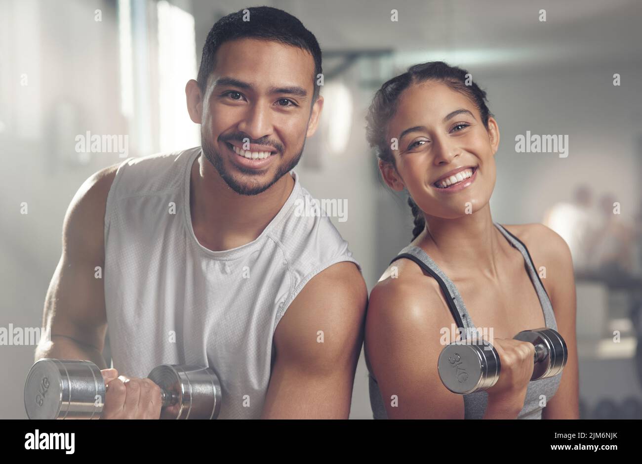 Working out makes us happy. two young athletes holding dumbbells Stock ...