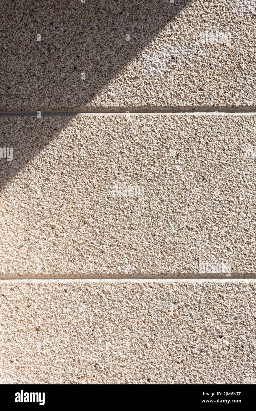 Granite stone wall texture background with shadow. Beige color Bush ...