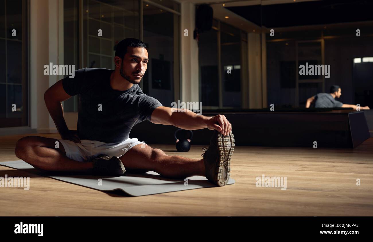 Getting in a solid stretch. Full length shot of a handsome young male ...