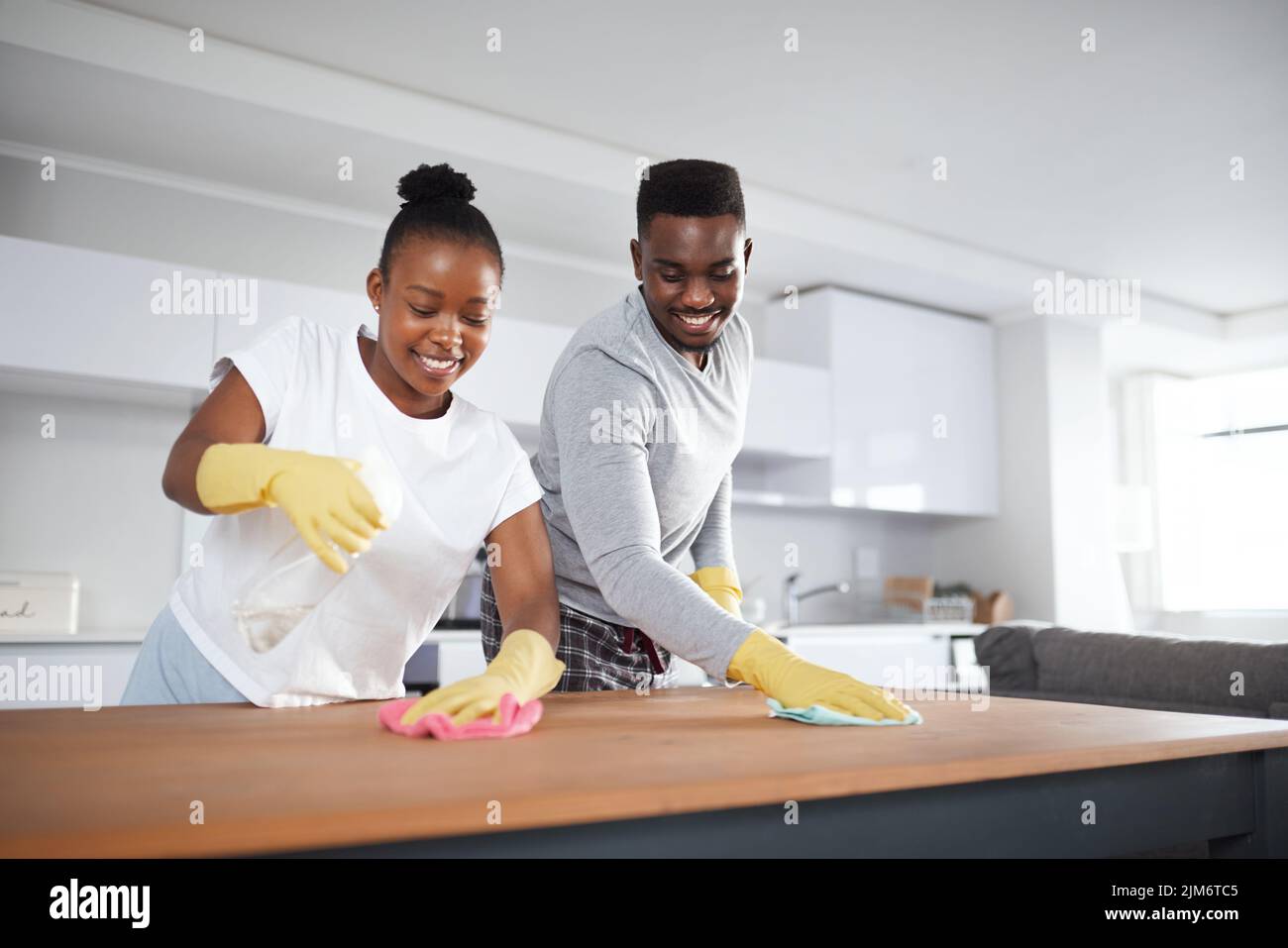A hygienic home is a healthy home. a young couple cleaning the kitchen ...