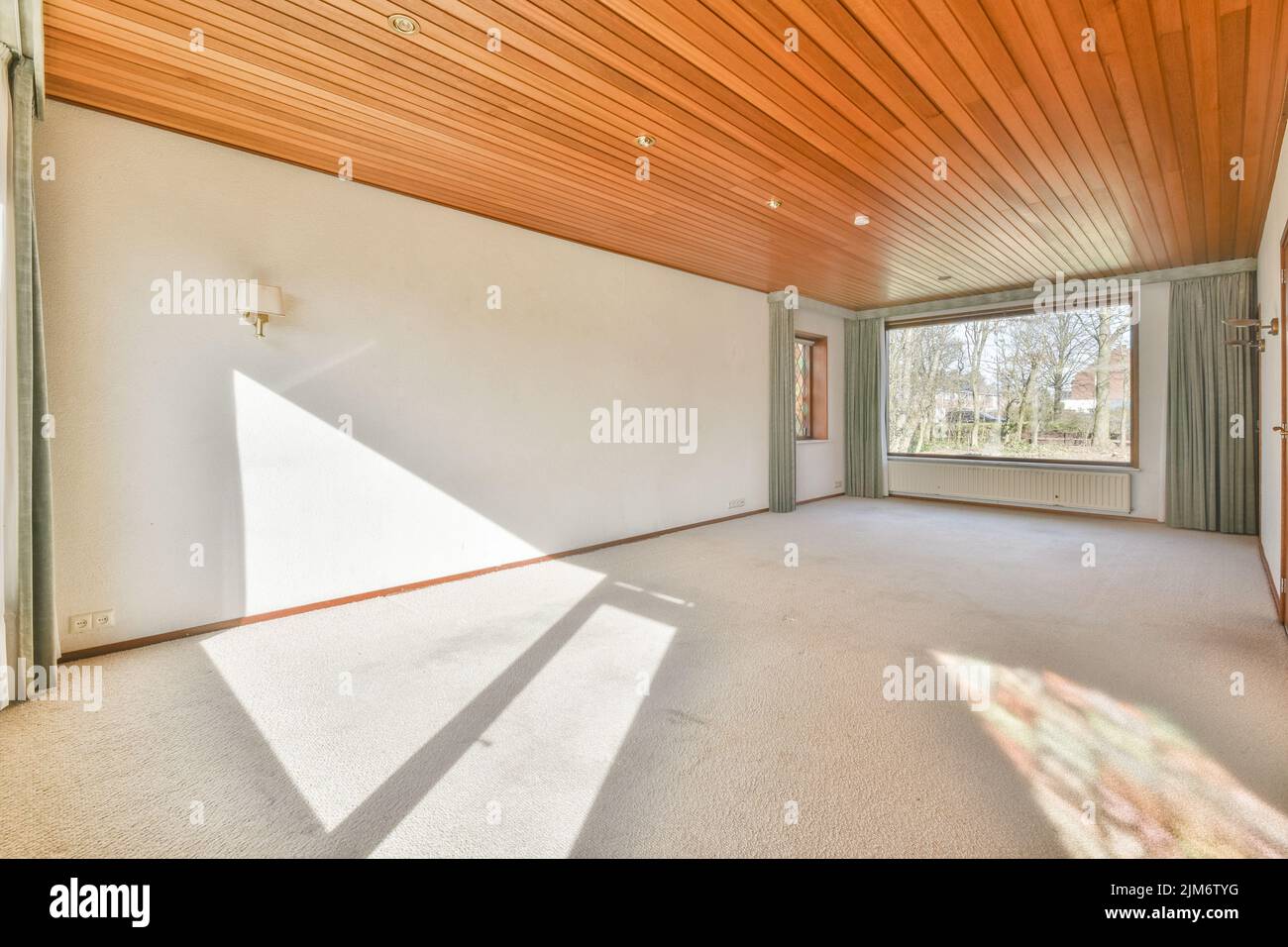 Plastic window and radiator on white wall in empty light room at home ...