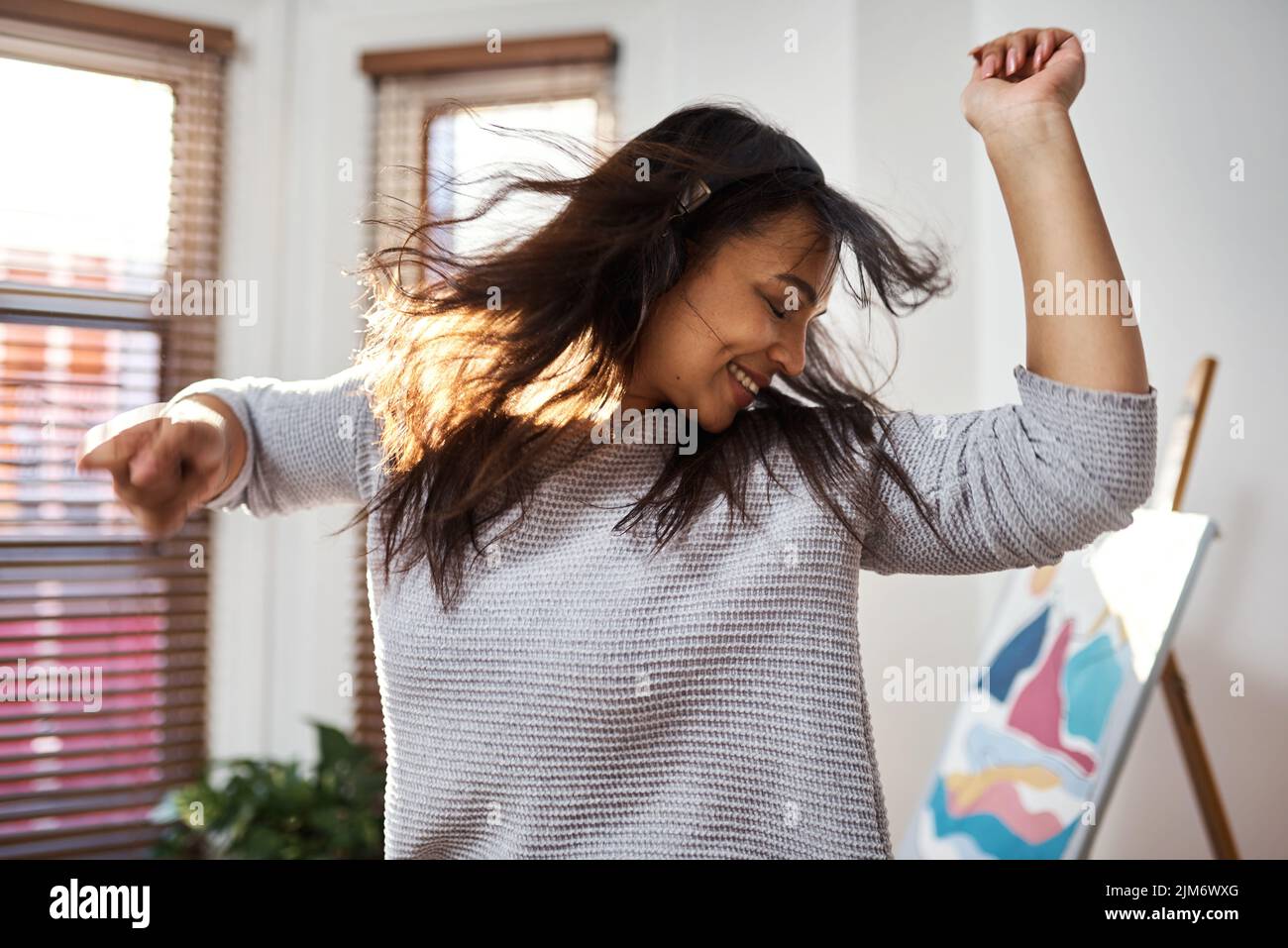 Happiness is dancing like crazy to your favourite song. a young woman ...