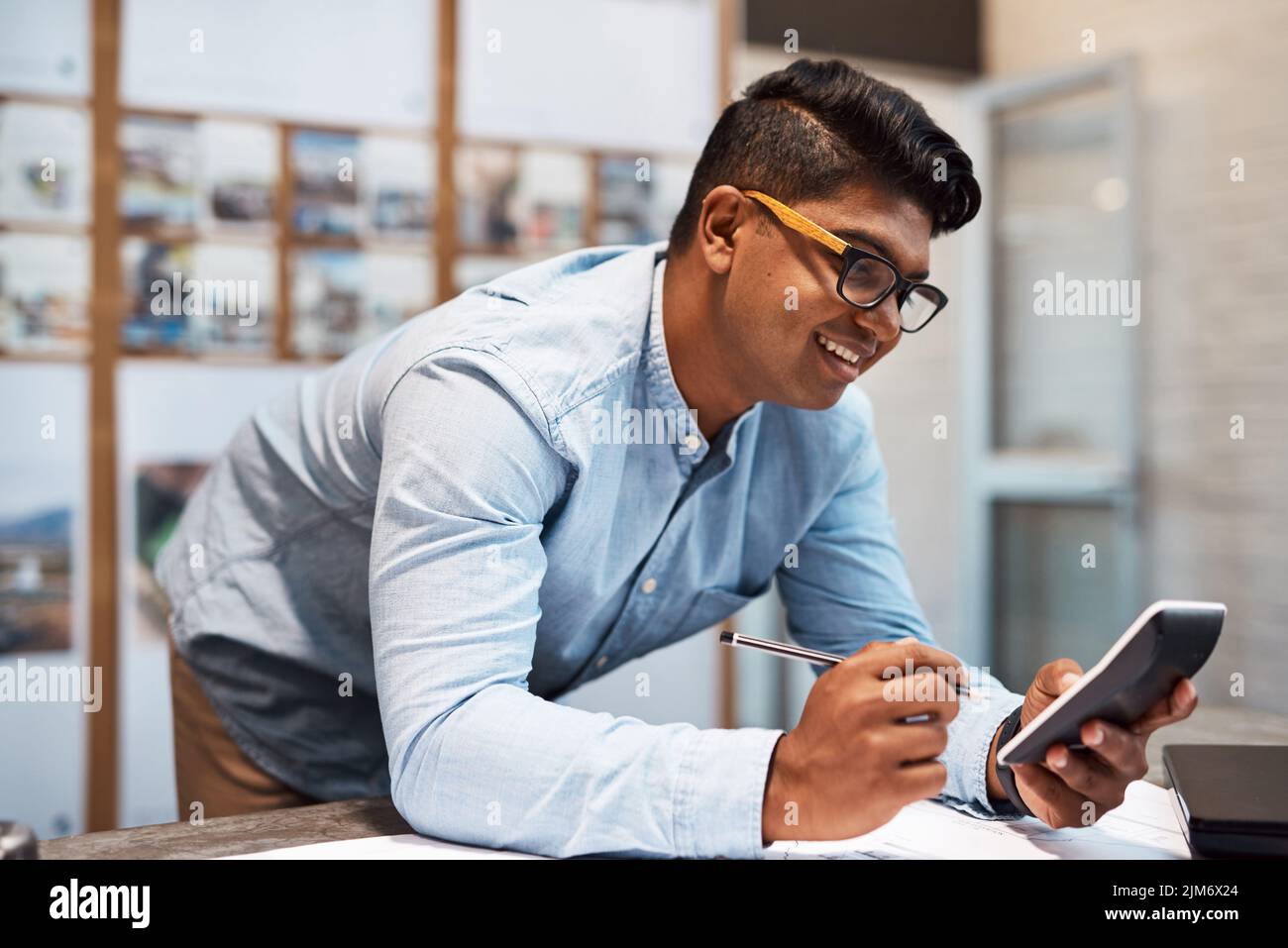 Planning the way to a profitable day. a young architect using a ...