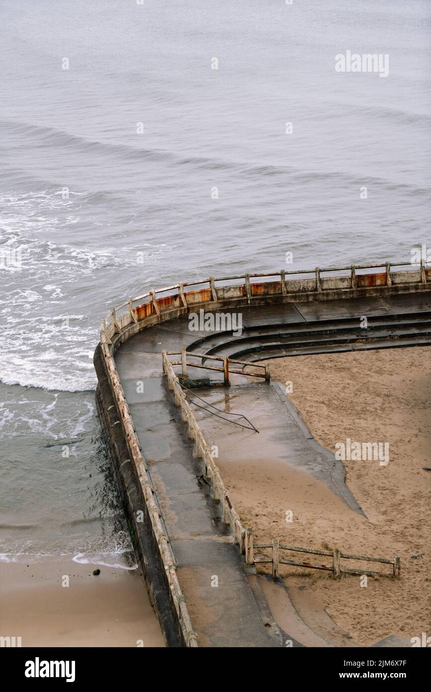 A vertical aerial view of a metal jetty on Tynemouth Beach in England ...