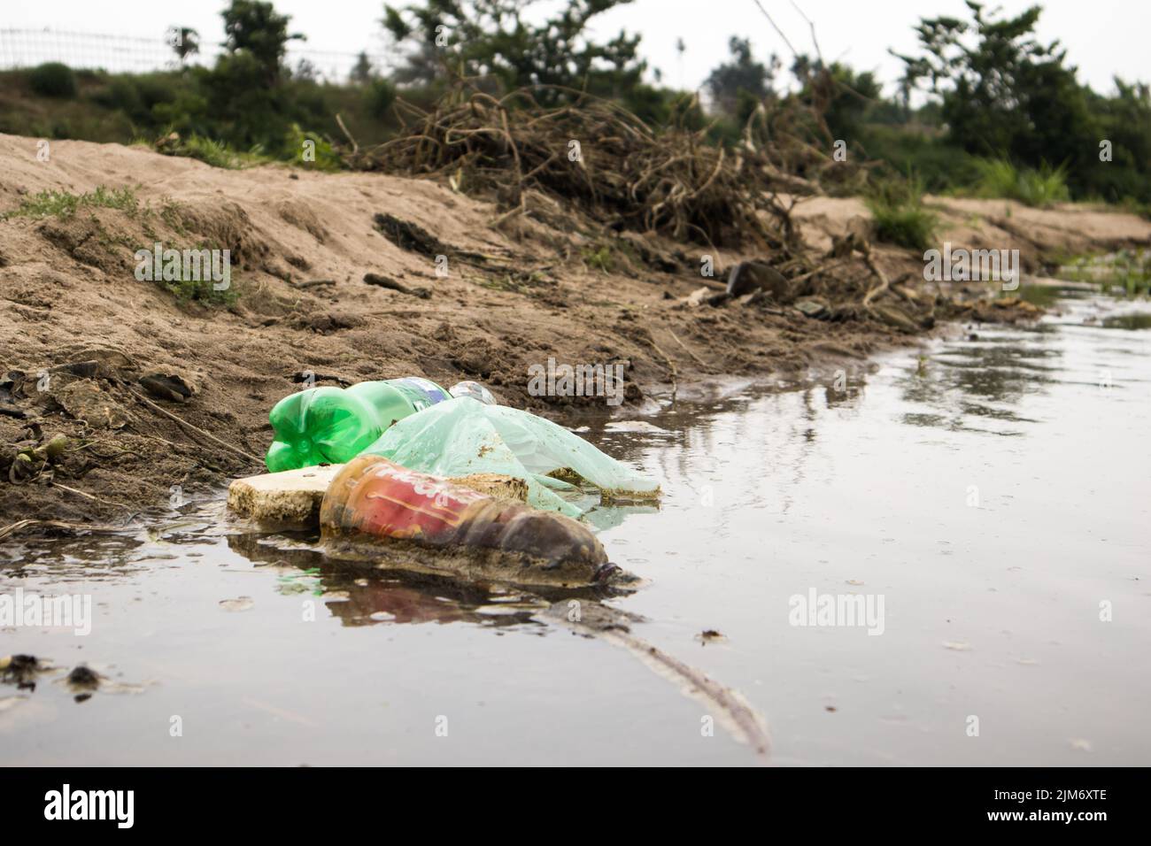The junk items are thrown in the water of the river, polluting the ...