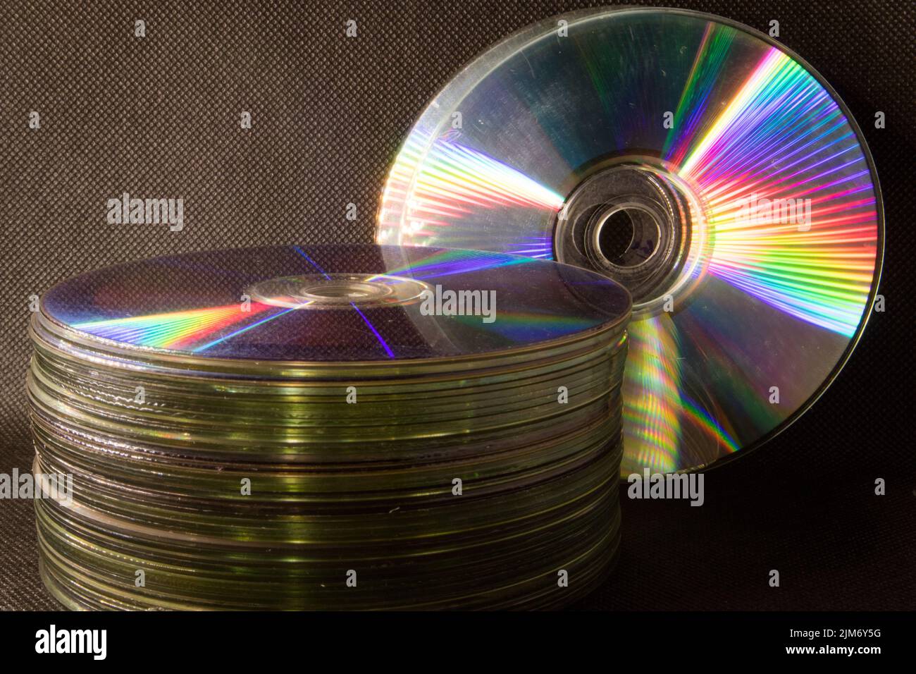 Some old Compact Disk, DVDs stacked in a black surface Stock Photo - Alamy