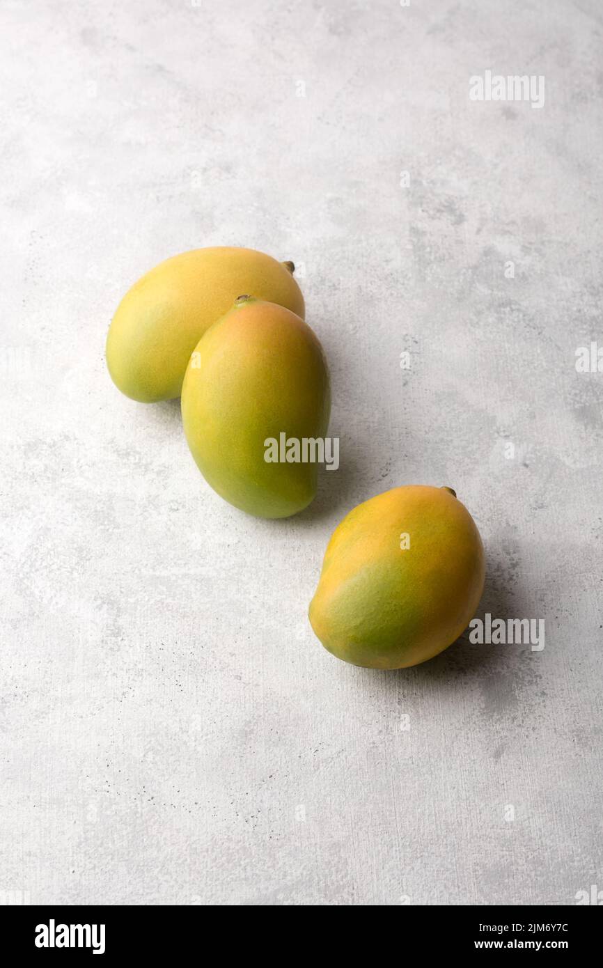 mangoes, tropical fruit on white textured surface background, copy ...