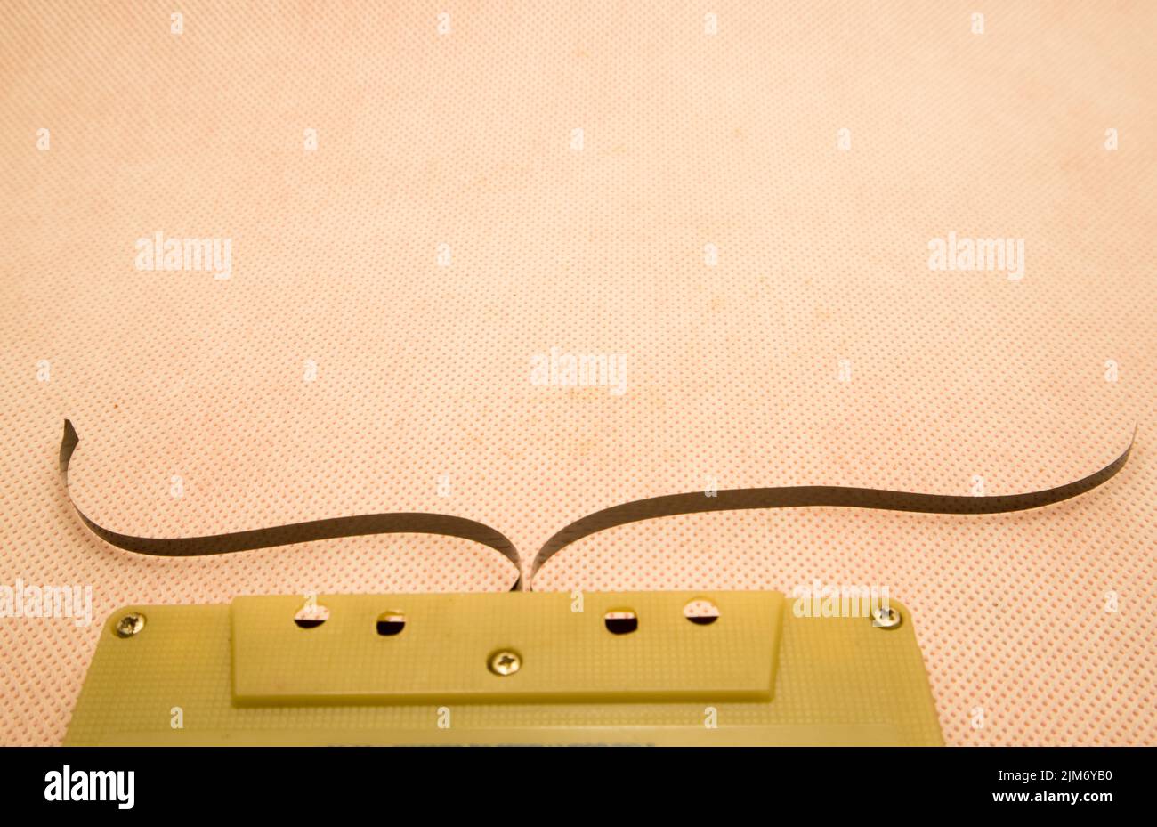 A torn magnetic tape of an audio cassette. Tape is taken out from its ...