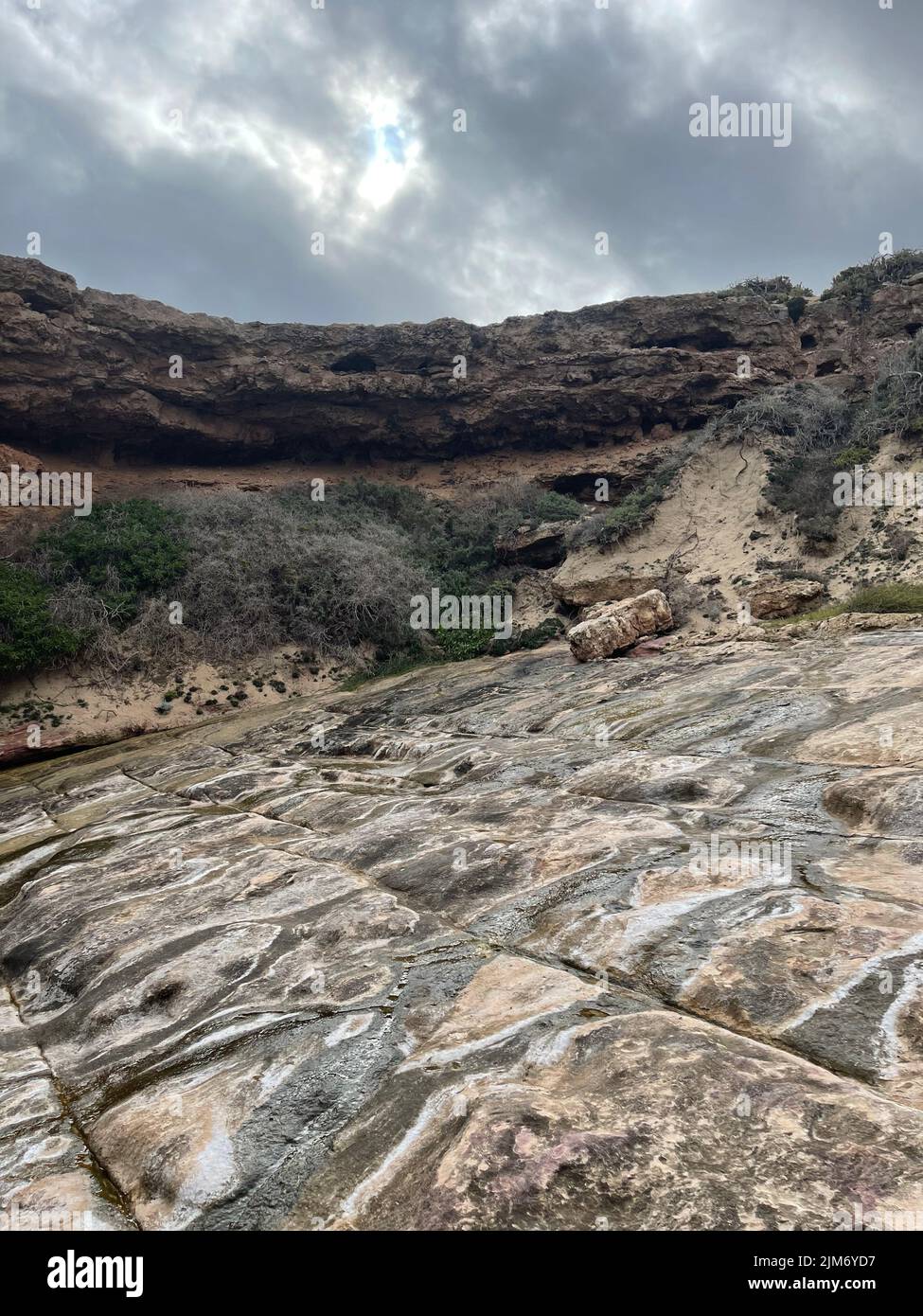 A vertical shot of a rocky cliff under a stormy sky in Horsham ...