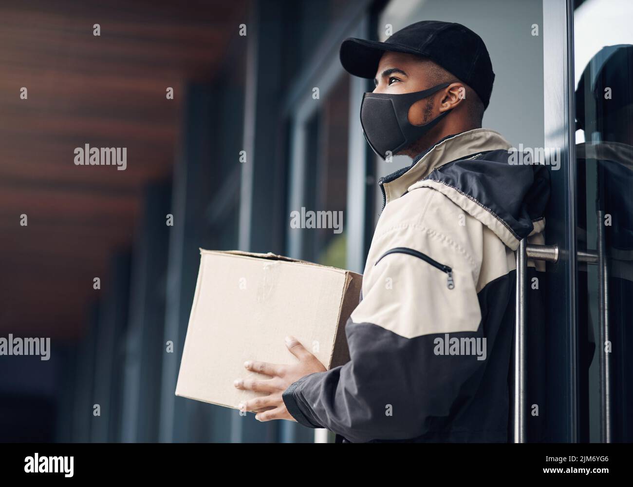 Is anybody home. a masked young man delivering a package to a place of ...