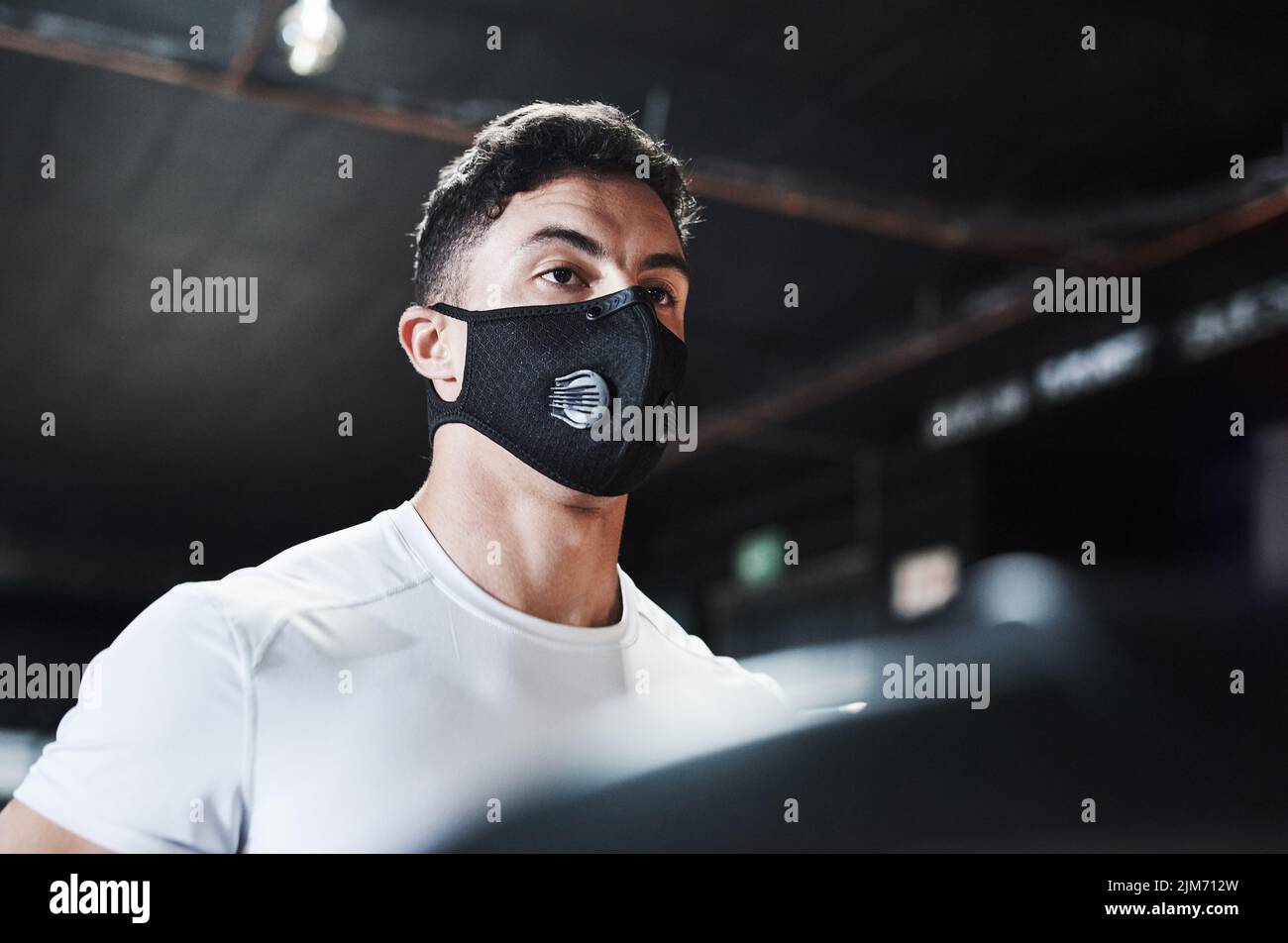 Health and safety. a handsome and athletic young man wearing a mask ...