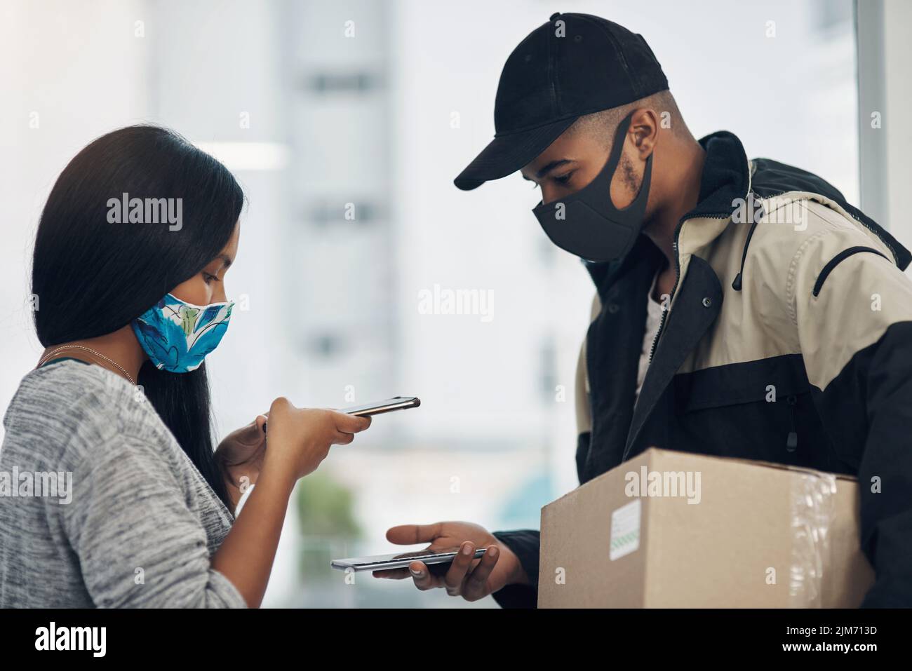 Contactless pay helps keep things under control. a masked young man and ...